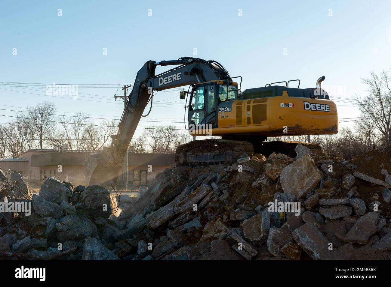 An excavator removes larger pieces of rubble after demolition begins on ...