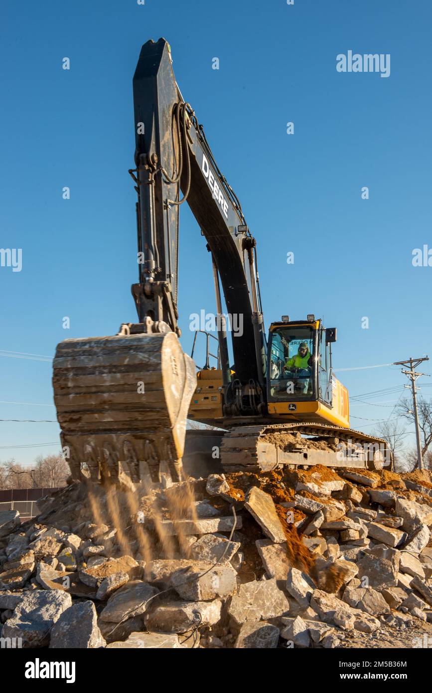 An excavator removes larger pieces of rubble after demolition begins on ...
