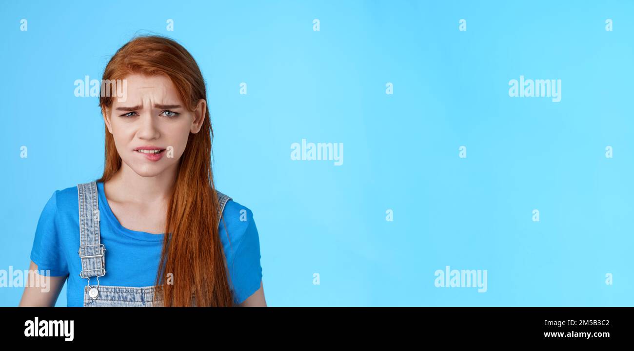 Uneasy upset redhead girl feel uncomfortable, stare frustrated, biting ...