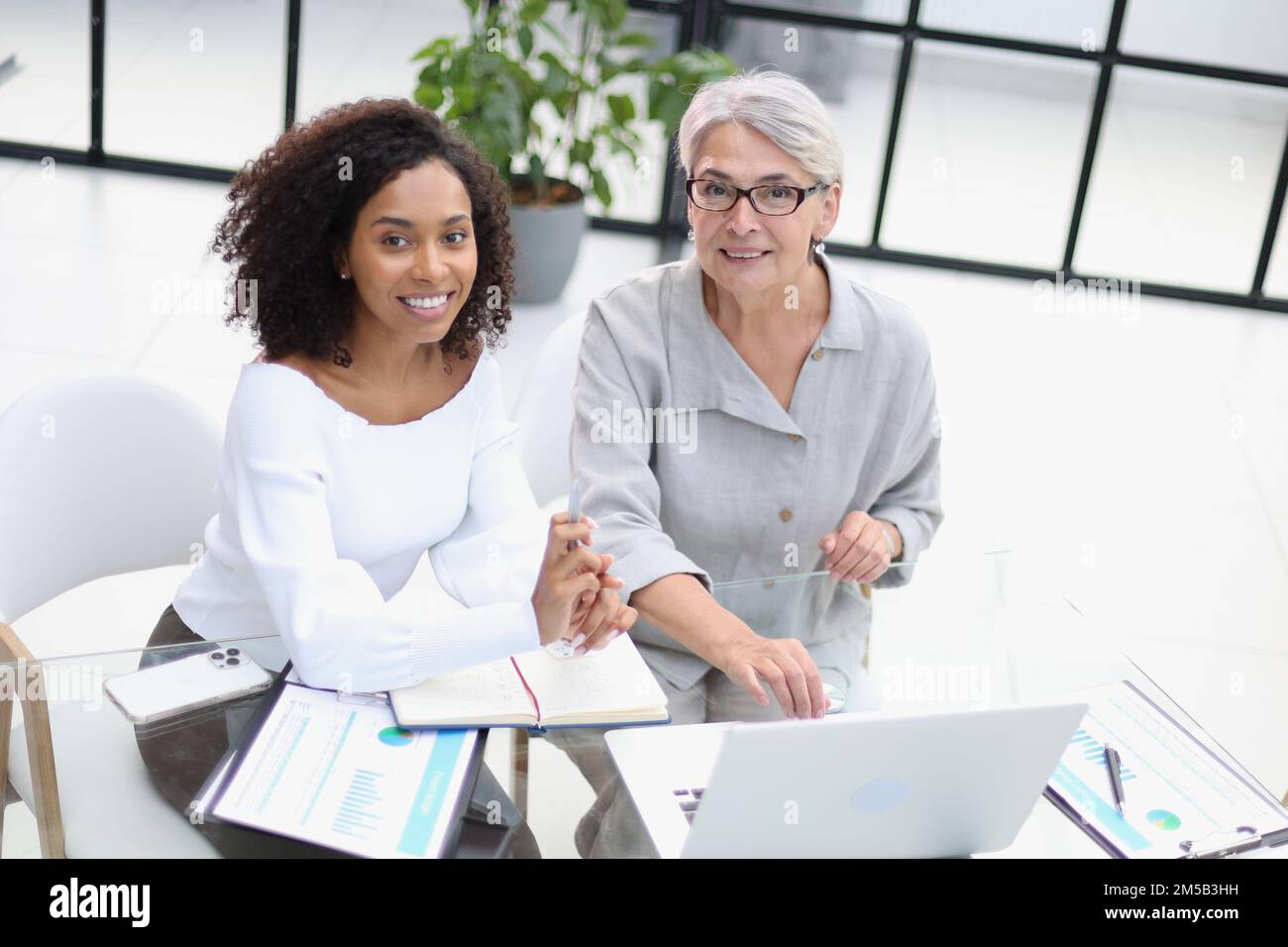Female colleagues met in the office hall discussing work issues Stock ...