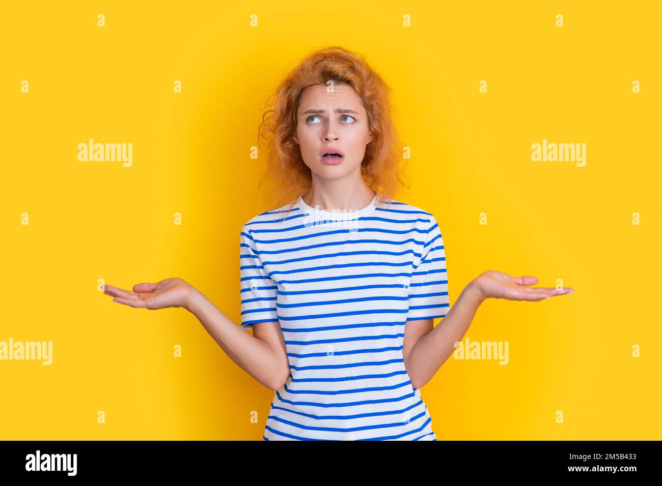 helpless redhead girl portrait isolated on yellow background. portrait ...