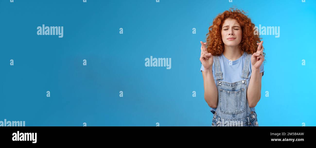 Intense nervous attractive redhead curly-haired hopeful focused girl ...