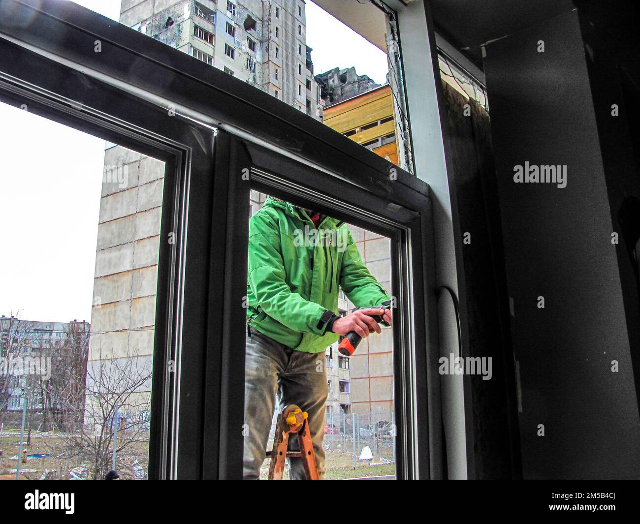 Kharkiv, Ukraine - 05.28.2022: man repair broken plastic window frame ...