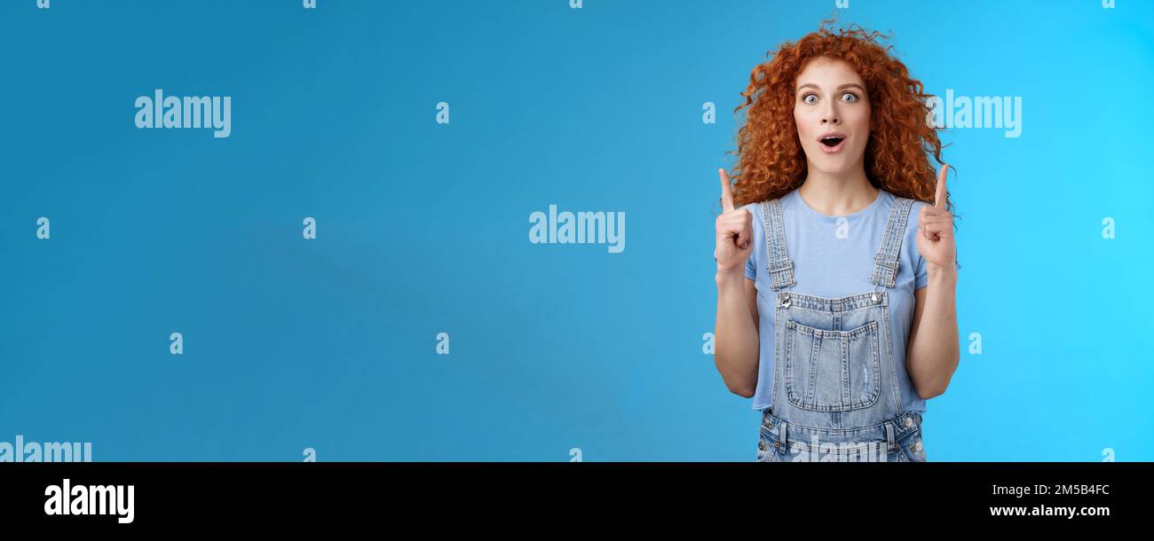 Amused astonished impressionable cute redhead curly girl open mouth ...