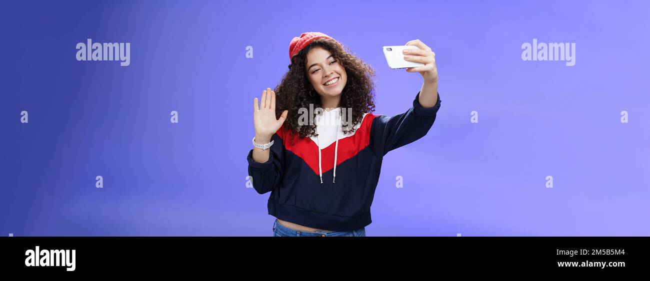 Studio shto of stylish cute female vlogger with curly hair in winter ...