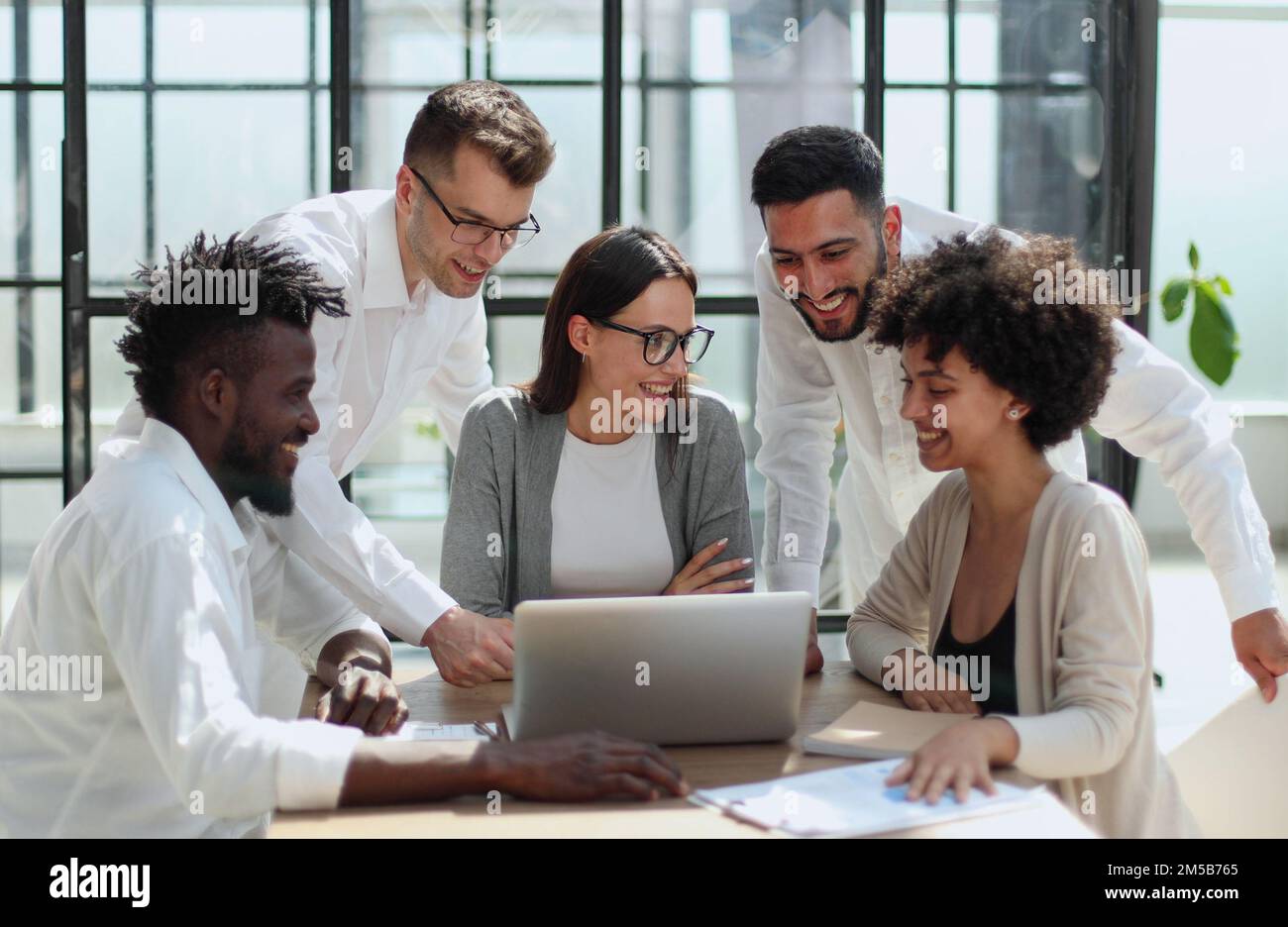Employees working at computer together, discussing content Stock Photo ...