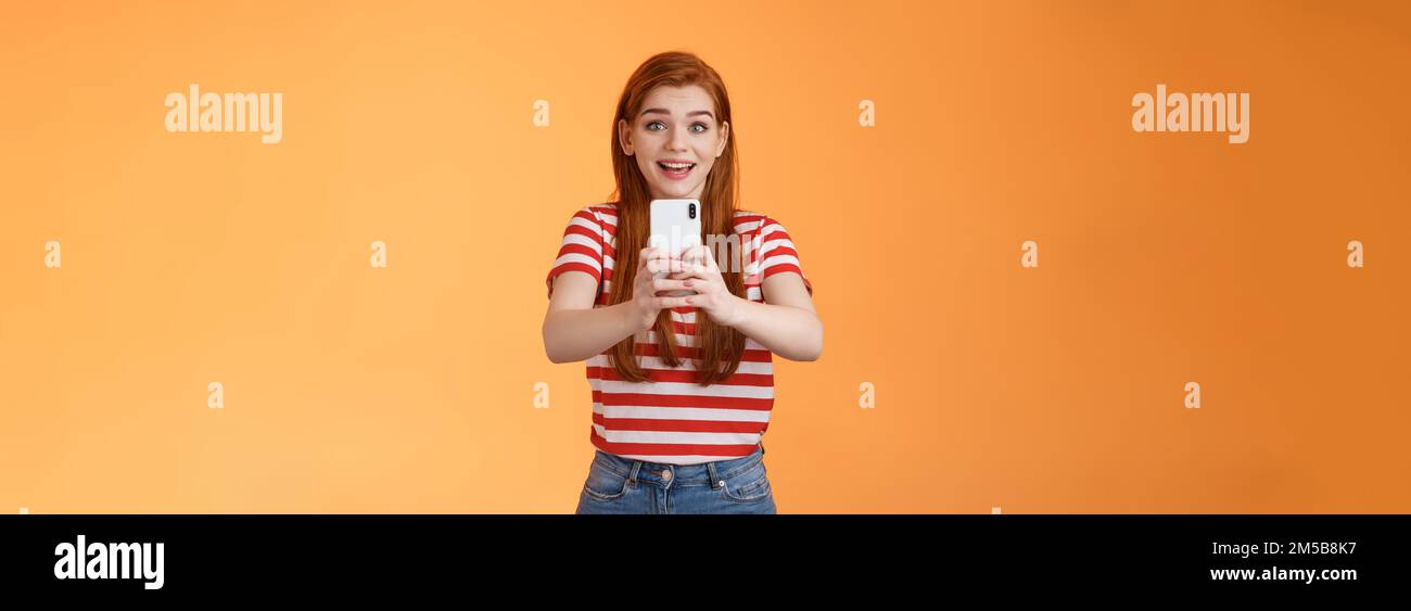 Amused excited redhead female record video thrilled see famous person ...