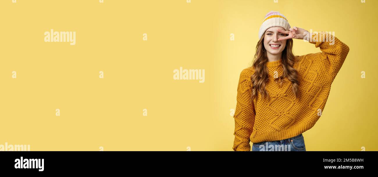 Positive peaceful kind charming young woman show peace victory gesture ...