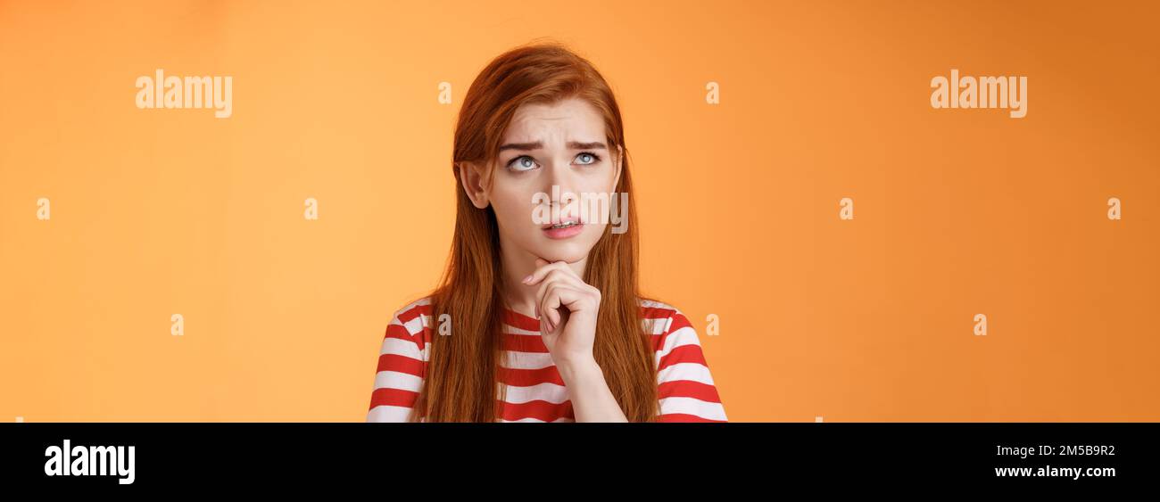 Perplexed redhead woman trying make calculations mind, frowning focused ...