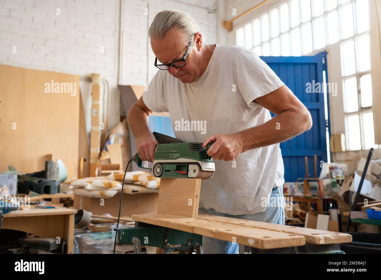 Carpenter working on wood craft at workspace producing wooden furniture ...
