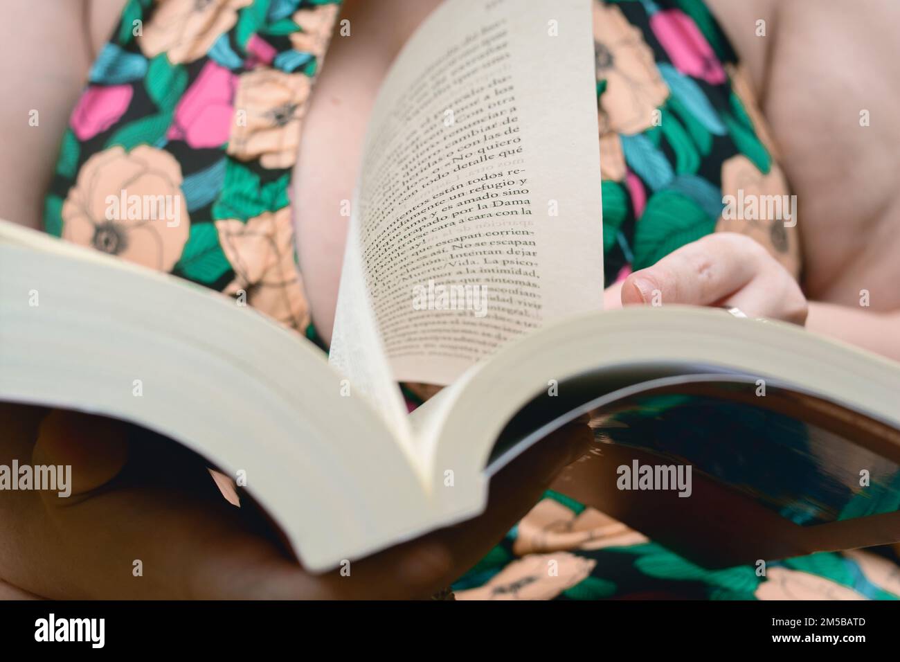 closeup front view of an open thick book being held by an ...
