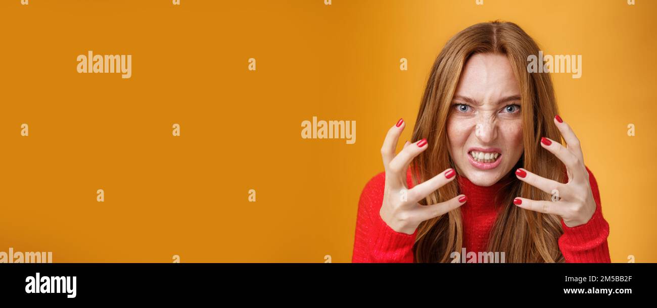 Close-up sot of pissed and angry redhead woman raising hands and ...