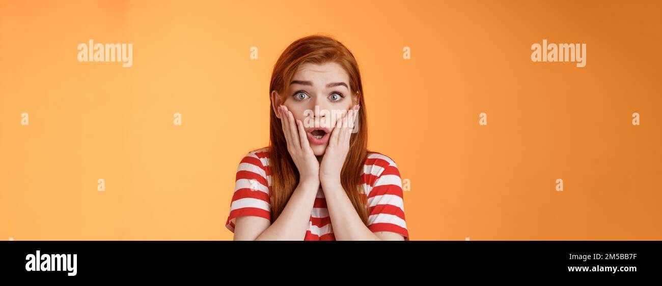Close-up shocked speechless redhead woman, drop jaw gasping, touch ...