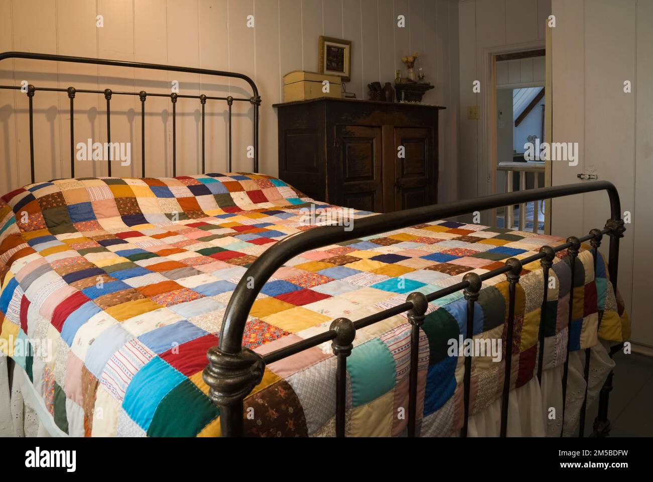 Antique brass double bed covered with patchwork quilt in main guest ...