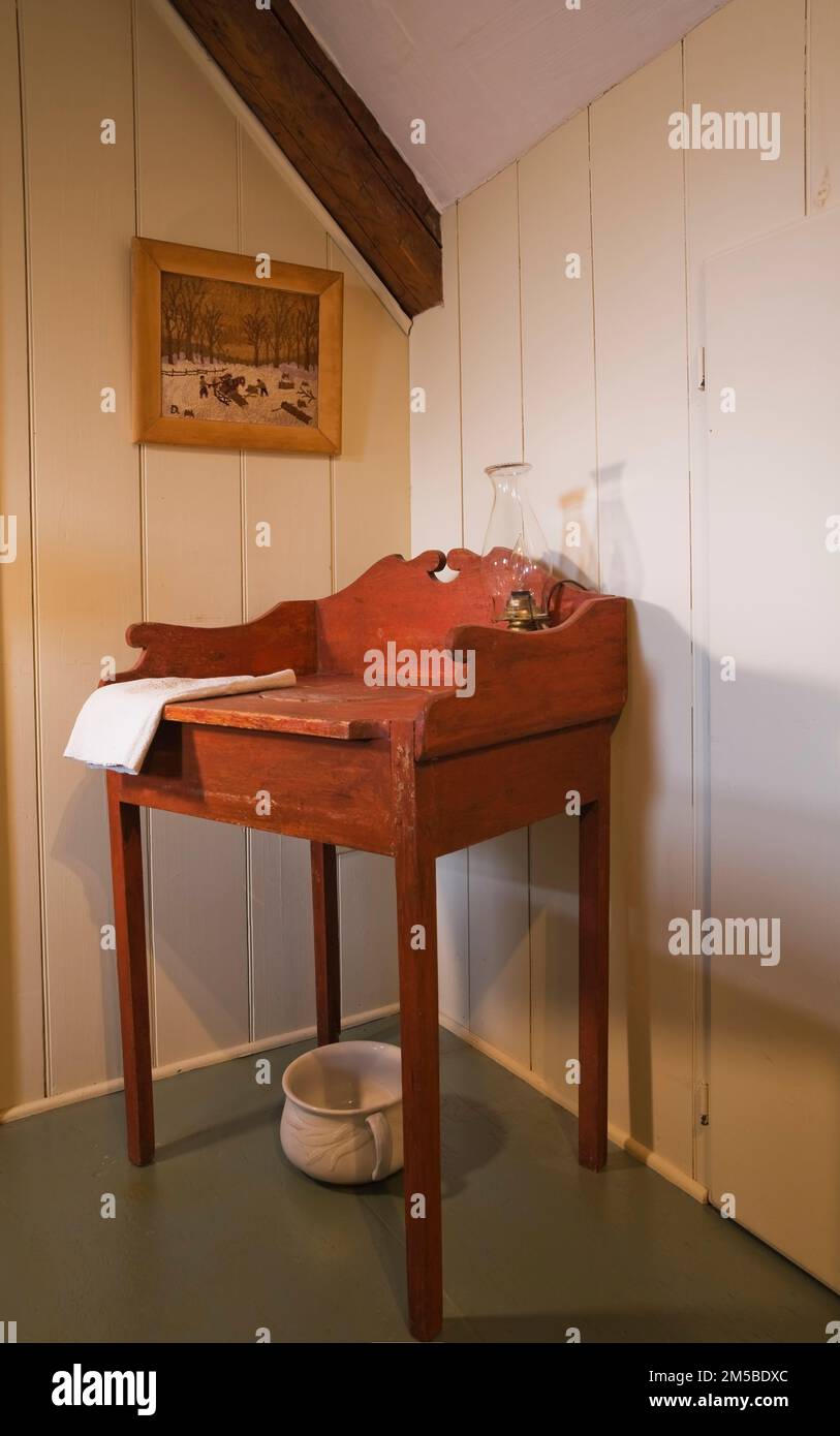 Red stained wooden antique wash stand in hallway on upstairs floor with ...