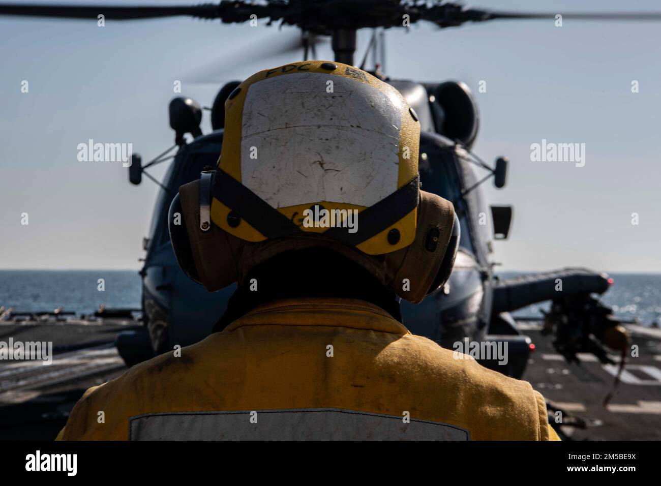 GULF OF OMAN (Feb. 21, 2022) Seaman Nicholas Steinhaus directs an MH ...