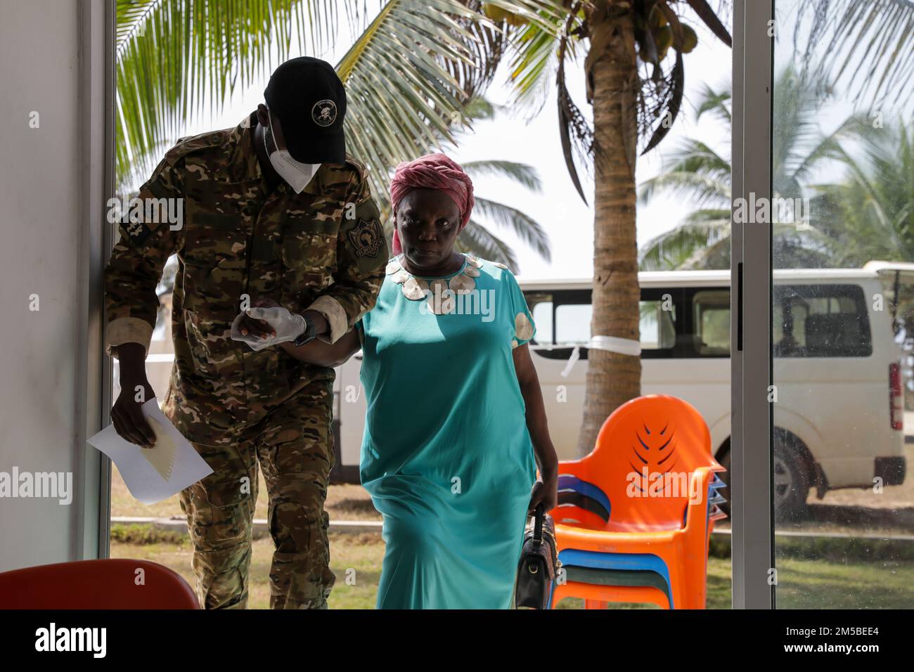 A Côte d’Ivoire Army medic assists a visually impaired elder during a ...