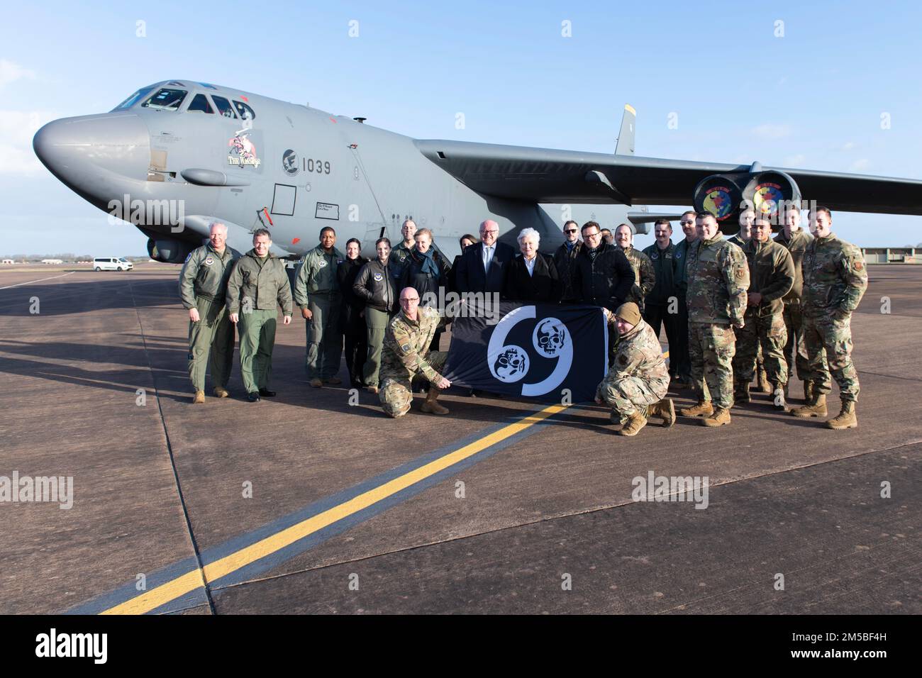 U.S. Air Force Airmen and distinguished dignitaries and guests stand ...