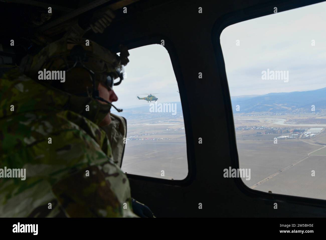 A pararescueman assigned to the 57th Rescue Squadron looks out the door ...