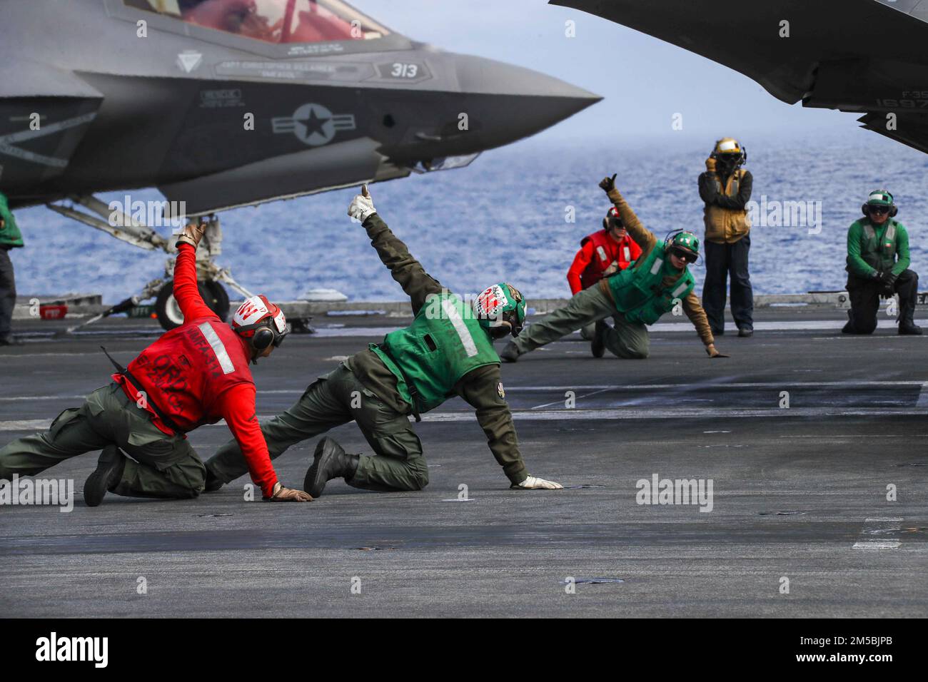 PHILIPPINE SEA (Feb. 23, 2022) Marines signal an F-35C Lightning II ...