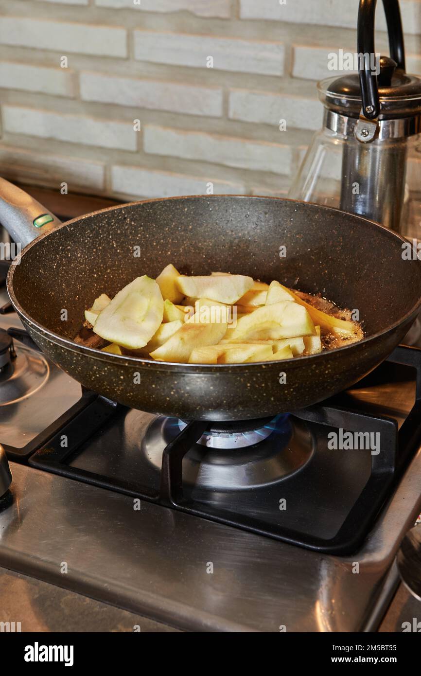 Frying pan on gas stove on fire with pears in syrup Stock Photo - Alamy
