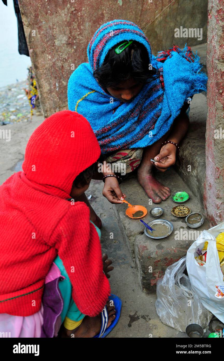 A Bengali woman preparing things for a puja ceremony on the banks of ...