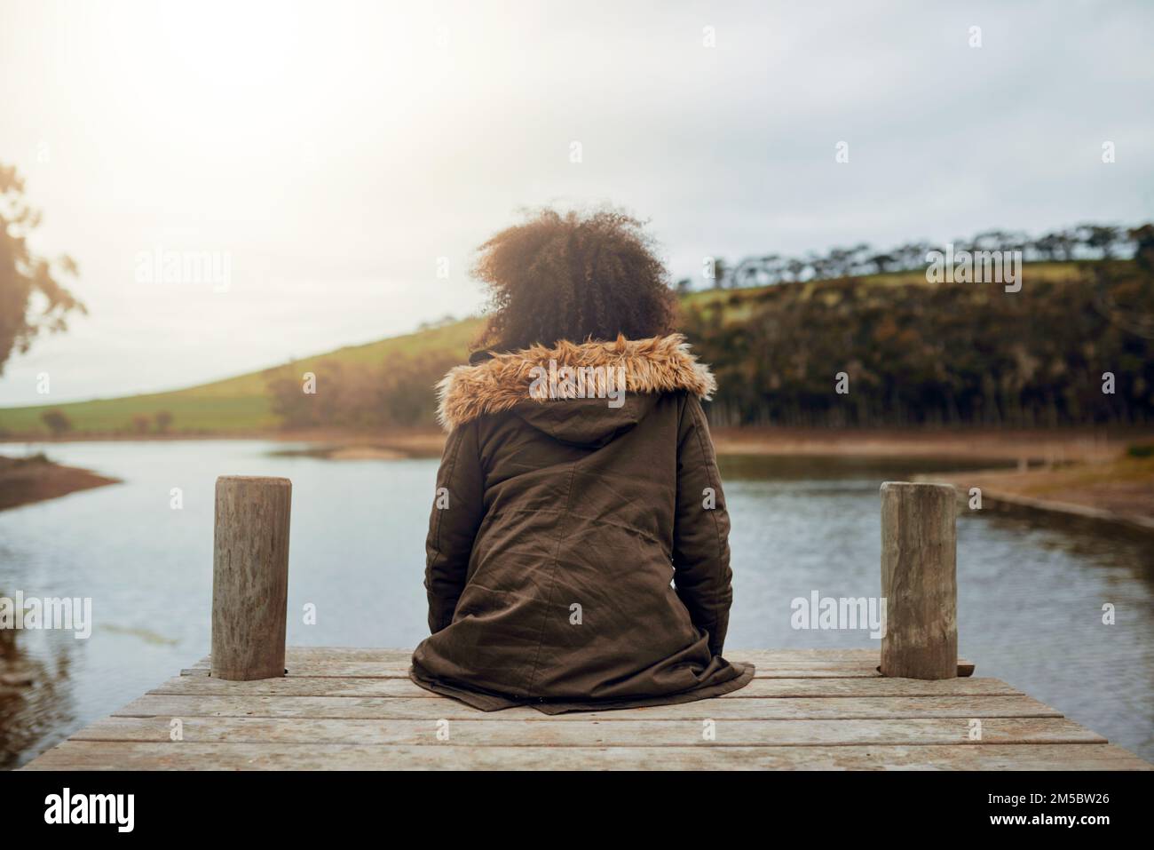 Taking time to reflect. Rearview shot of a young woman admiring the ...