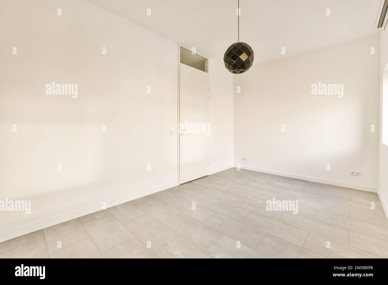 an empty room with white walls and wood flooring, there is a fan on the ...
