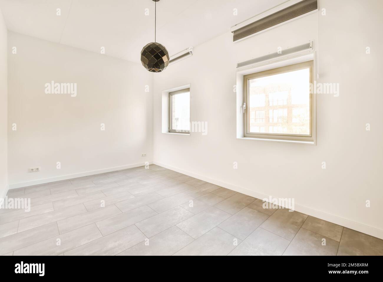 an empty room with white walls and wood flooring, there is a large ...