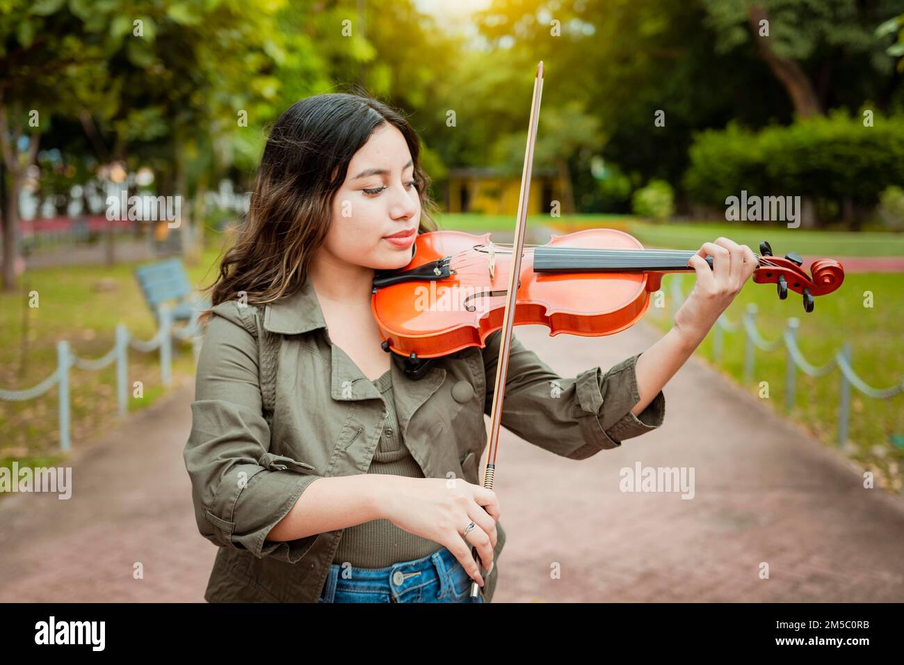 Woman playing the violin in the street. Close up of violinist girl ...