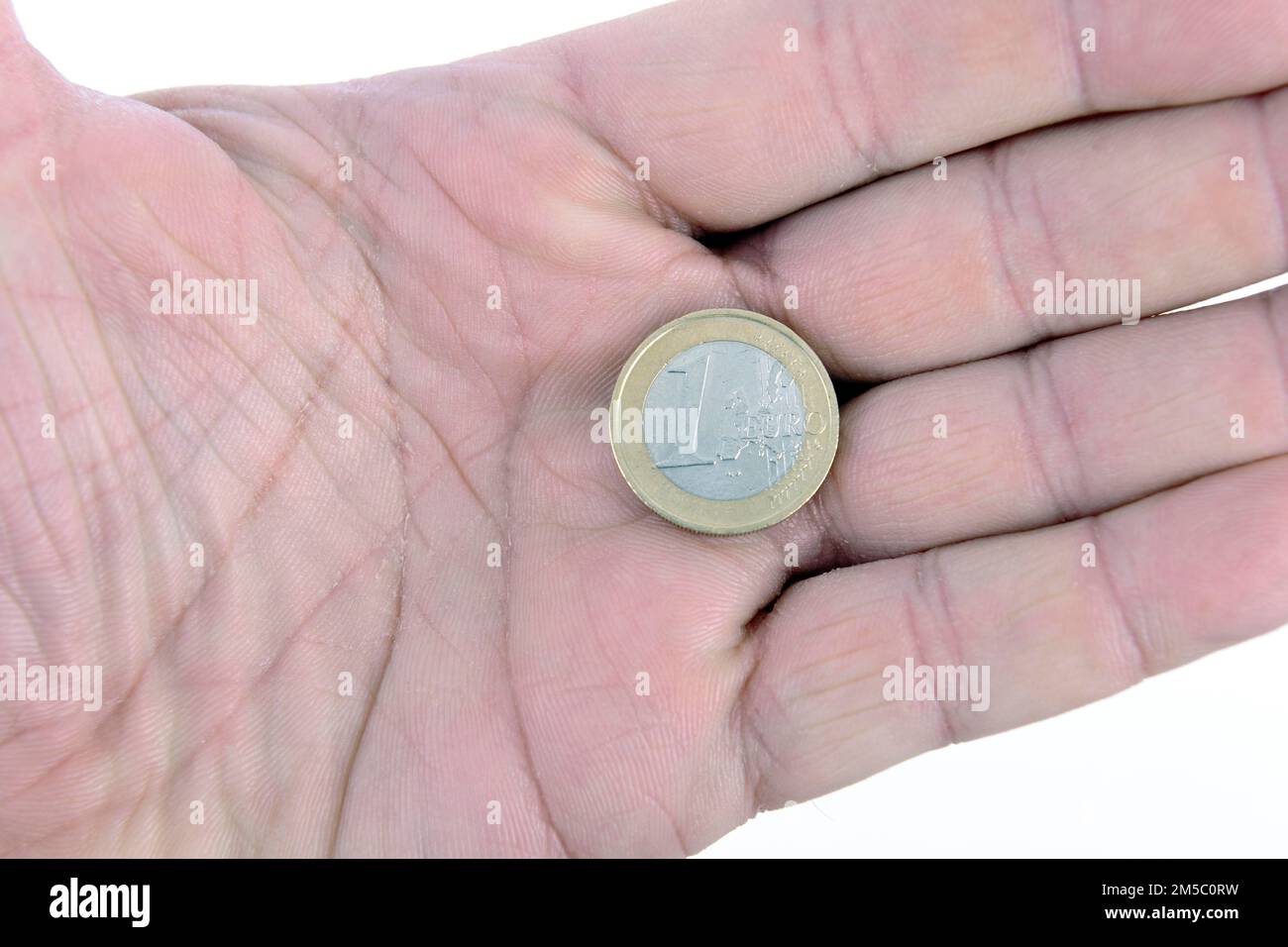 Coin, one euro in one hand Stock Photo - Alamy