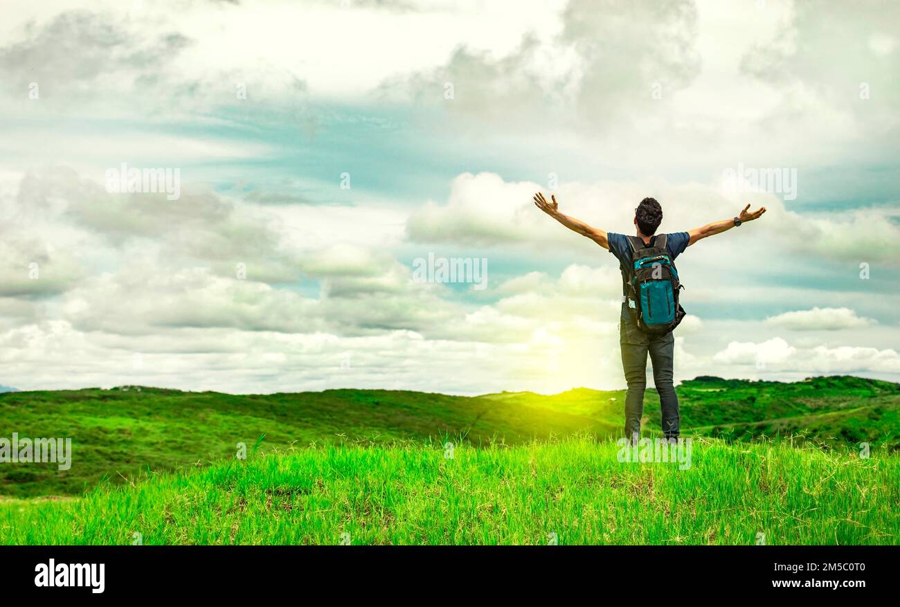 Man with backpack on a hill spreading his arms. Adventurous man ...