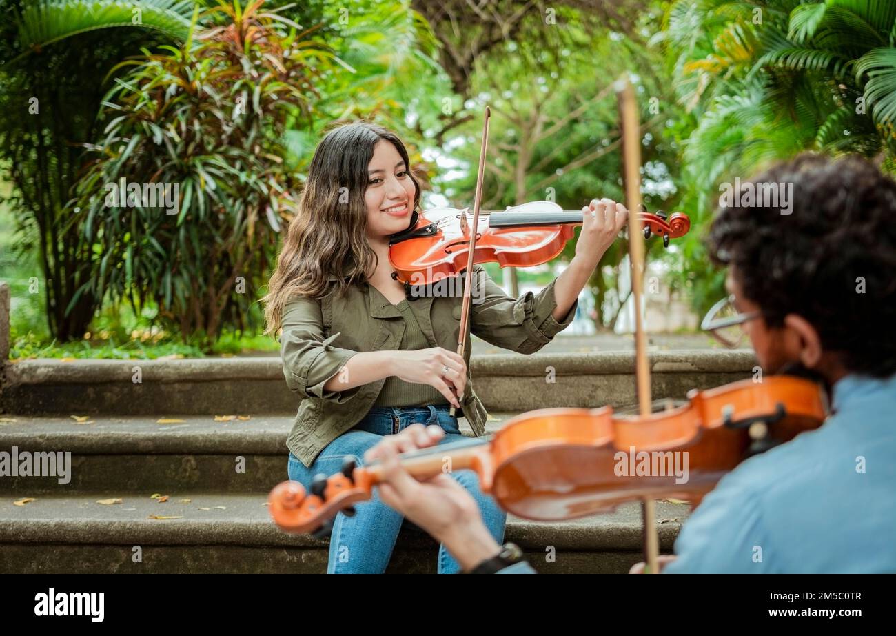 Portrait of violinist people sitting on stairs playing violin. Portrait ...