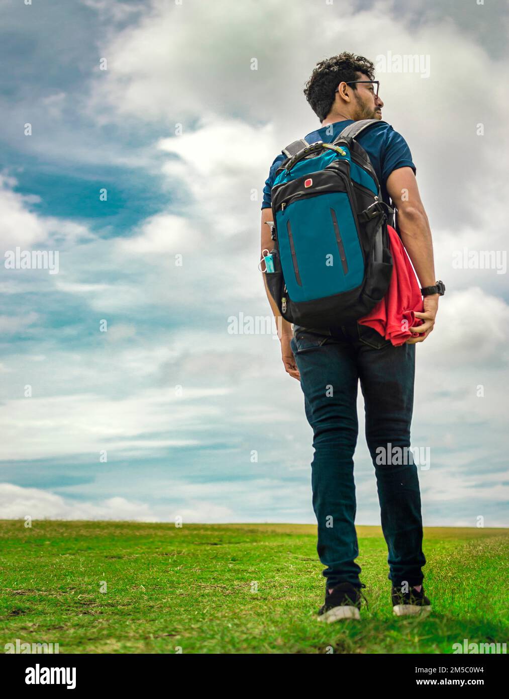 Low angle of traveler man walking in the field. Backpacker man walking ...