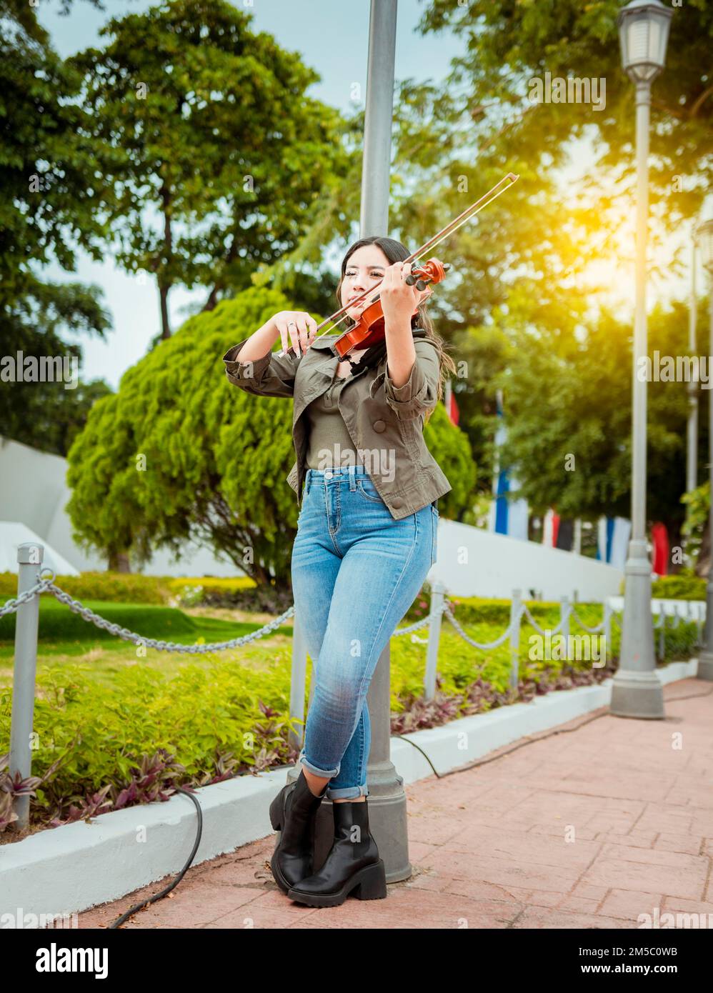 Woman playing violin in the street. Portrait of violinist girl playing ...