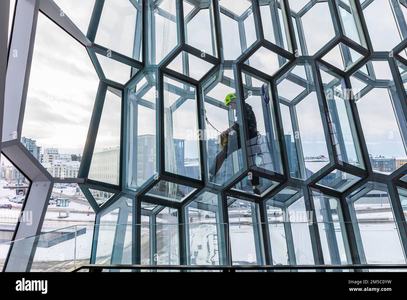 Window cleaners cleaning the glass facade of the Harpa Concert Hall and ...