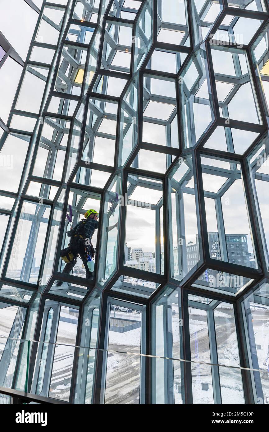 Window cleaners cleaning the glass facade of the Harpa Concert Hall and ...