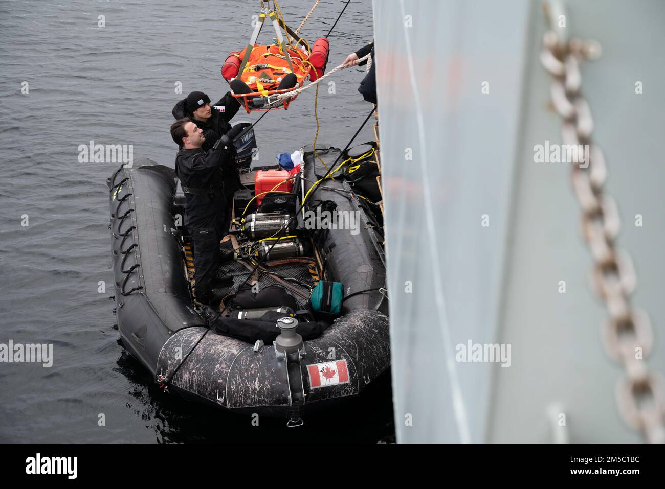 Sailors First Class Sam Brunet and Jarrett Theberge guide a stokes ...