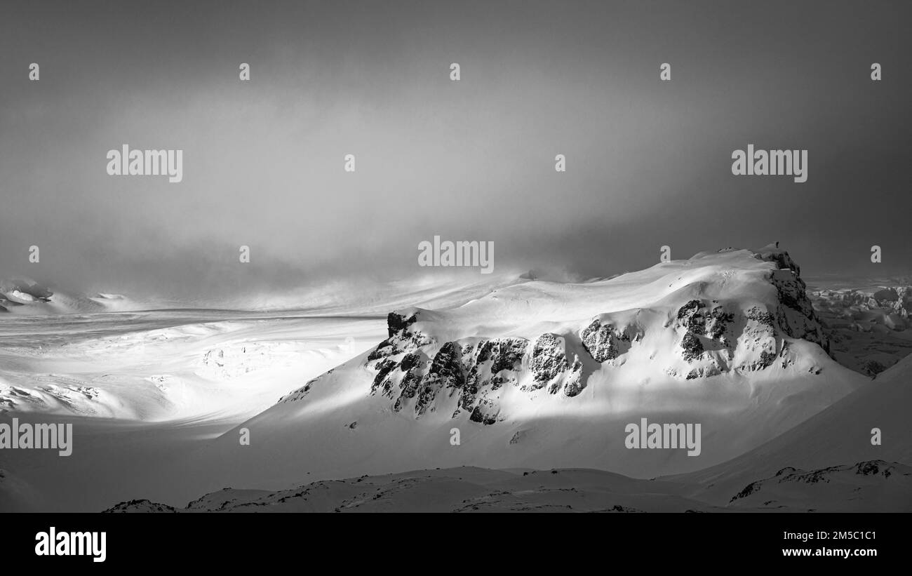 Fog, light and shadow on the snowy summit of Breidamerkurfjall, black ...