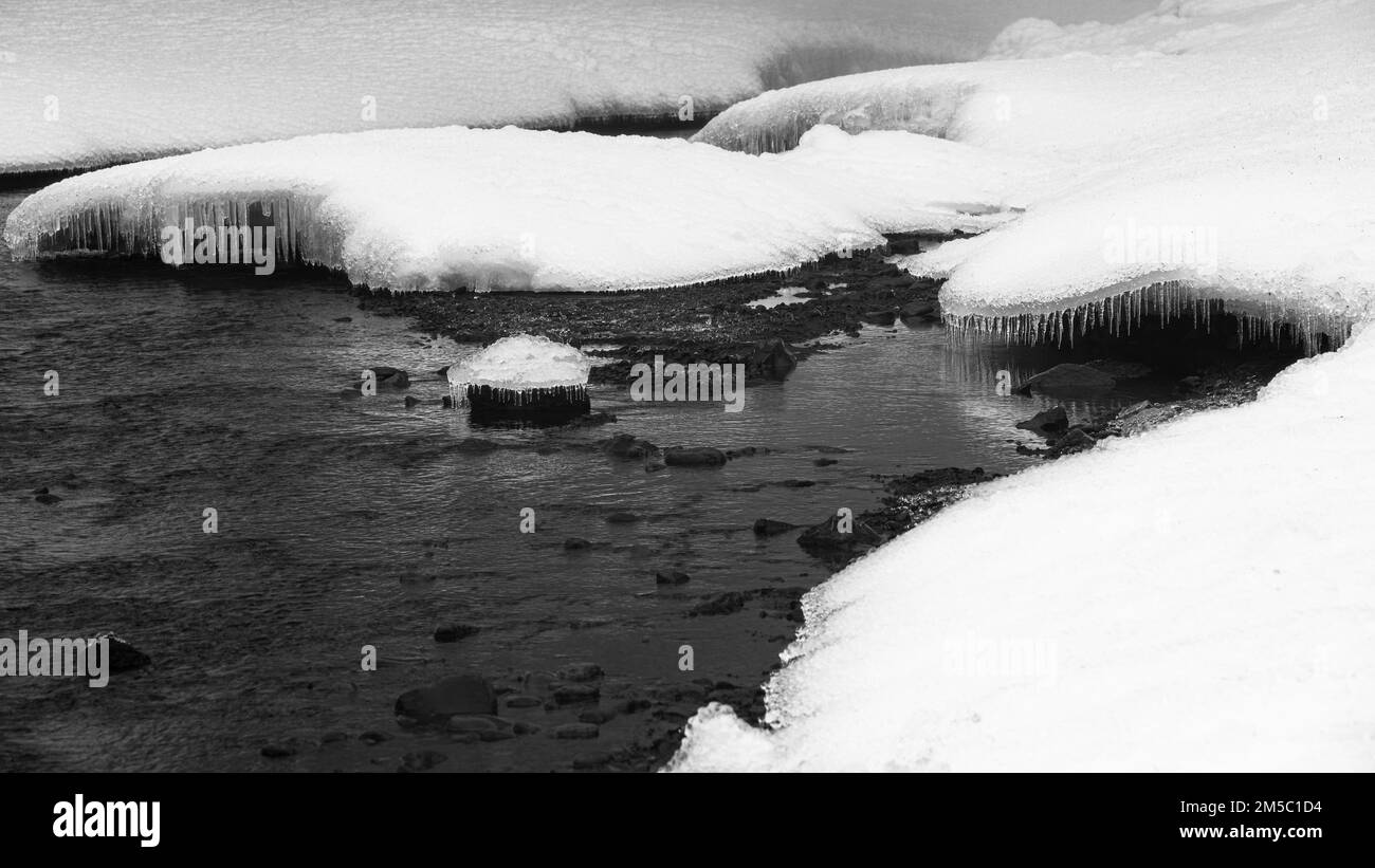 Snow mounds and icicles in the Skoga River below the Skogafoss ...