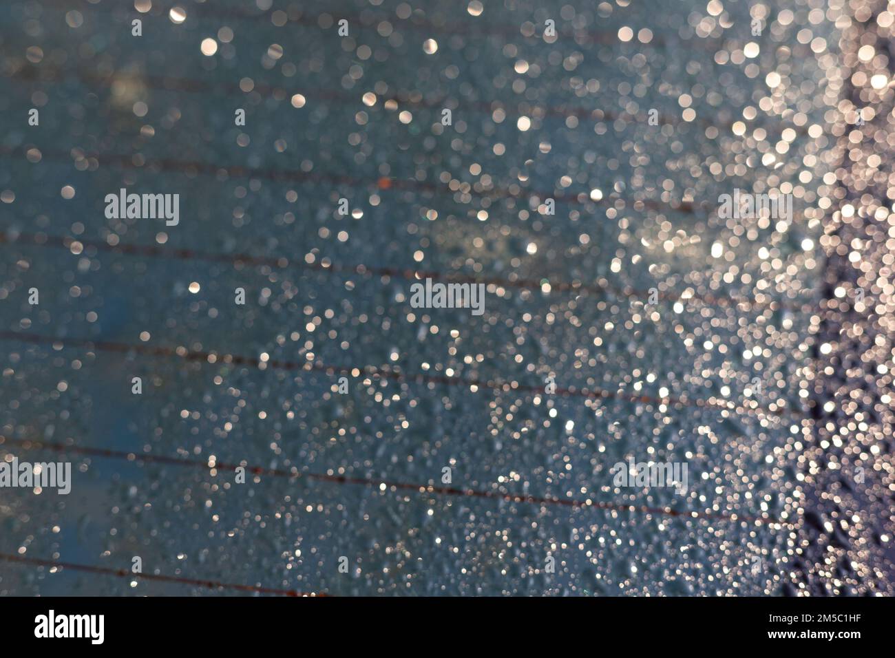 Water drops on car rear window with heating stripes visible in the ...