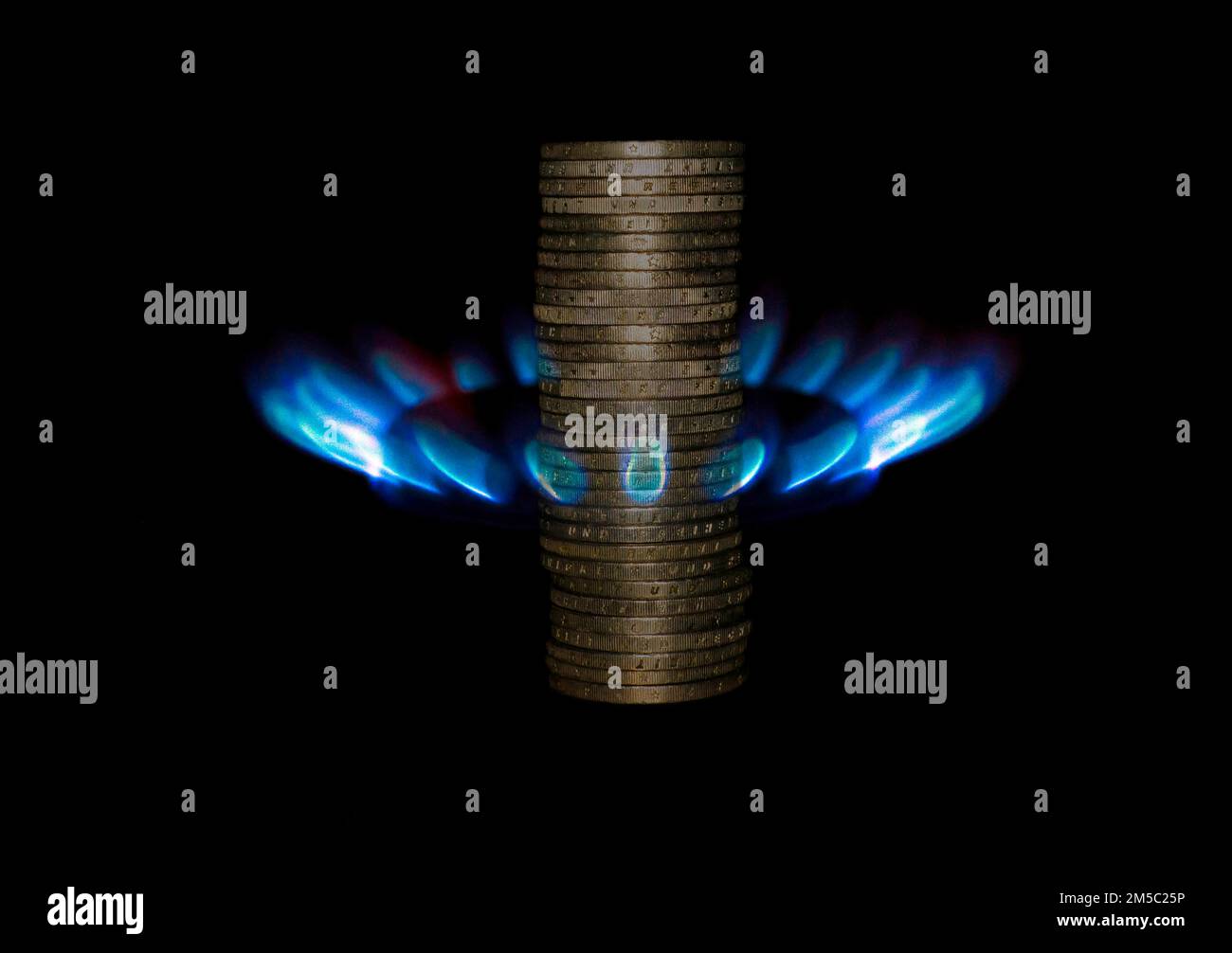 Symbol photo with a stack of 2 euro coins entwined by a blue gas flame ...