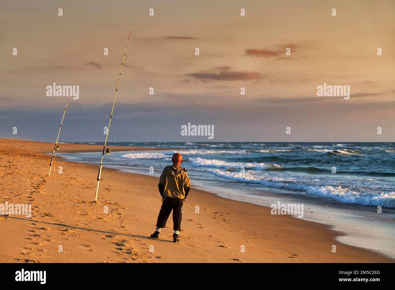 Surf fishing, angler standing with two rods on the beach, Soustons ...