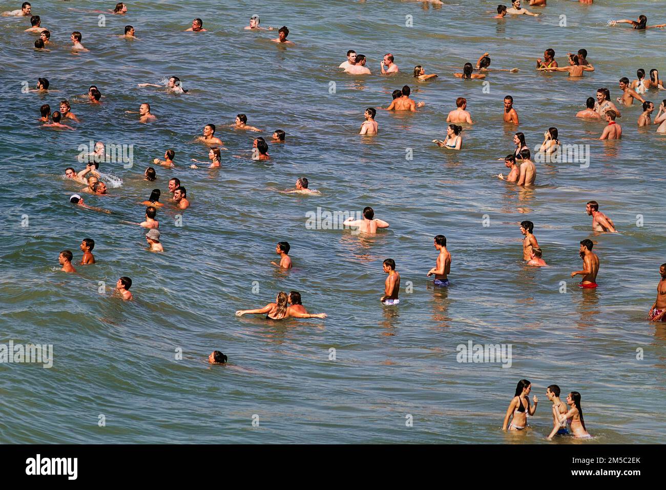View from above on crowd on the beach, tourists swimming in the sea ...