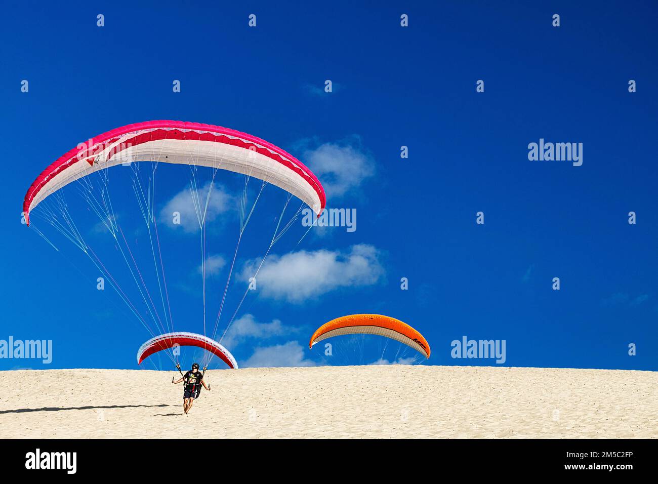 Three paragliders take off on a dune, coastal launch on the Dune du ...