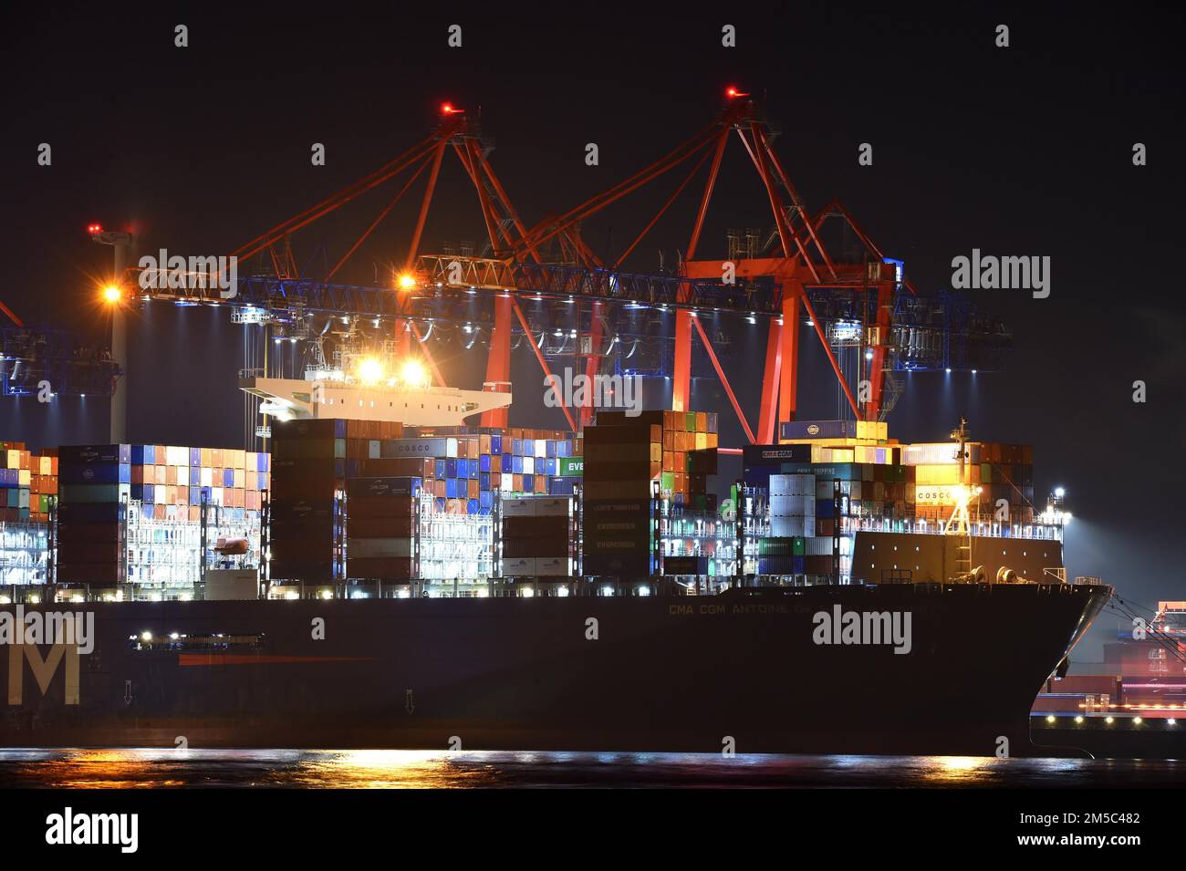 Container ships being loaded at night at the container terminal ...
