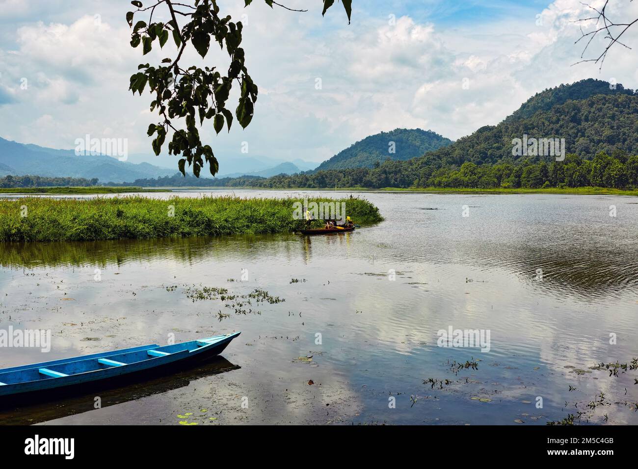 The people on the shore of Chandubi Lake with a cloudy blue sky in the ...