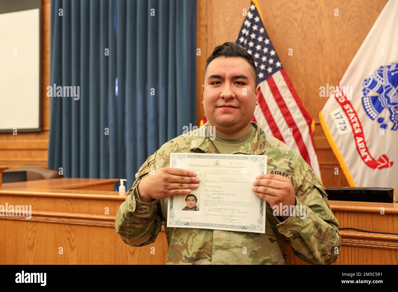 Pfc. Carlos Vasquez, a 1st Infantry Division Soldier, holds up his new ...