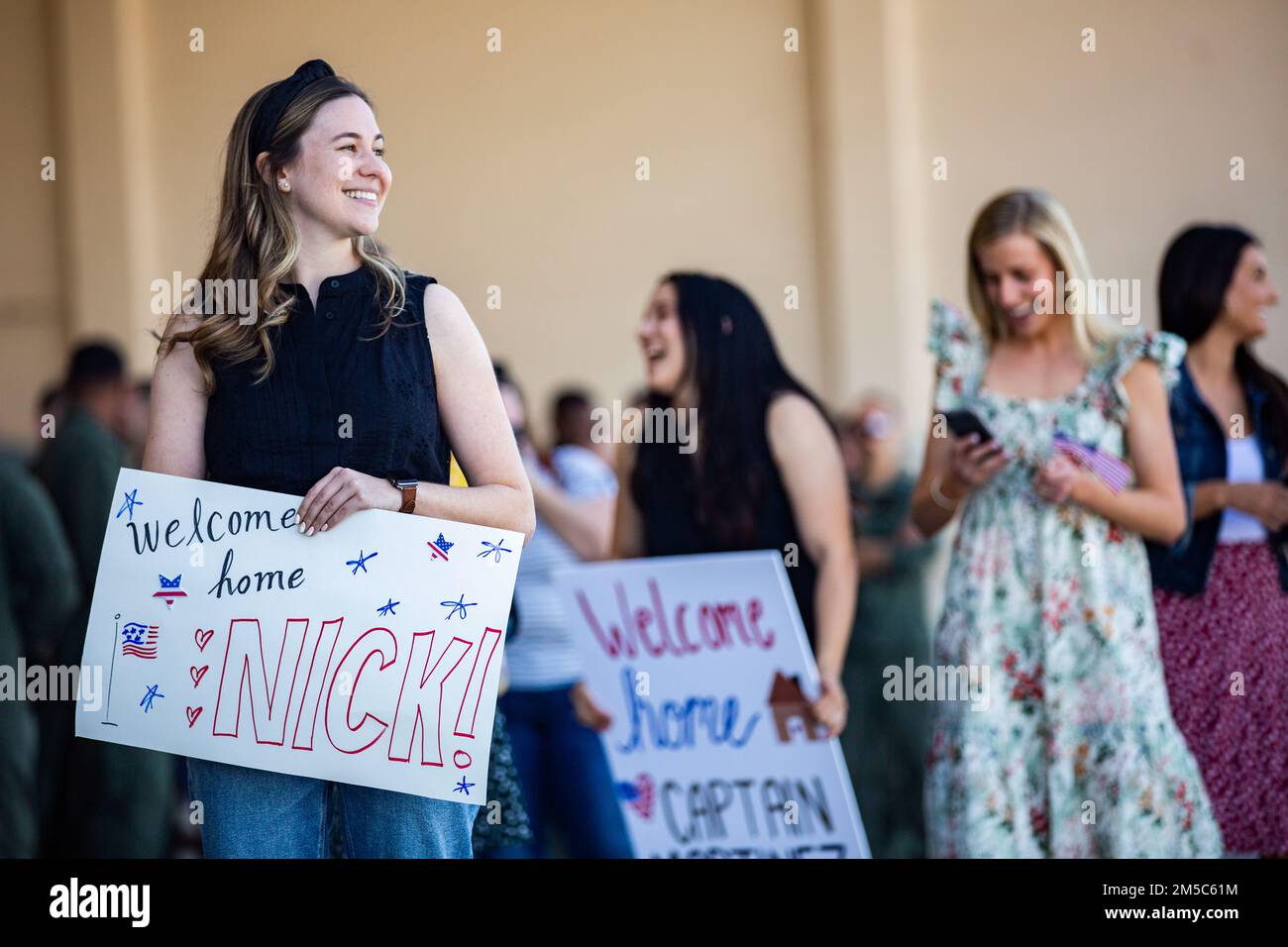 Family members await the arrival of U.S. Marines and Sailors with ...