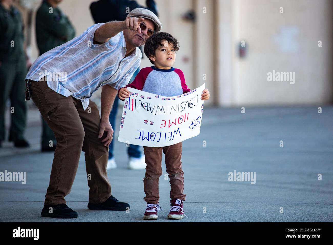Family members await the arrival of U.S. Marines and Sailors with ...